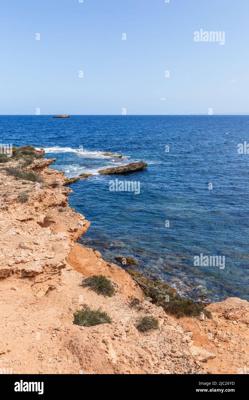 Orange color of coastal cliff, blue color of sea water and pale blue ...