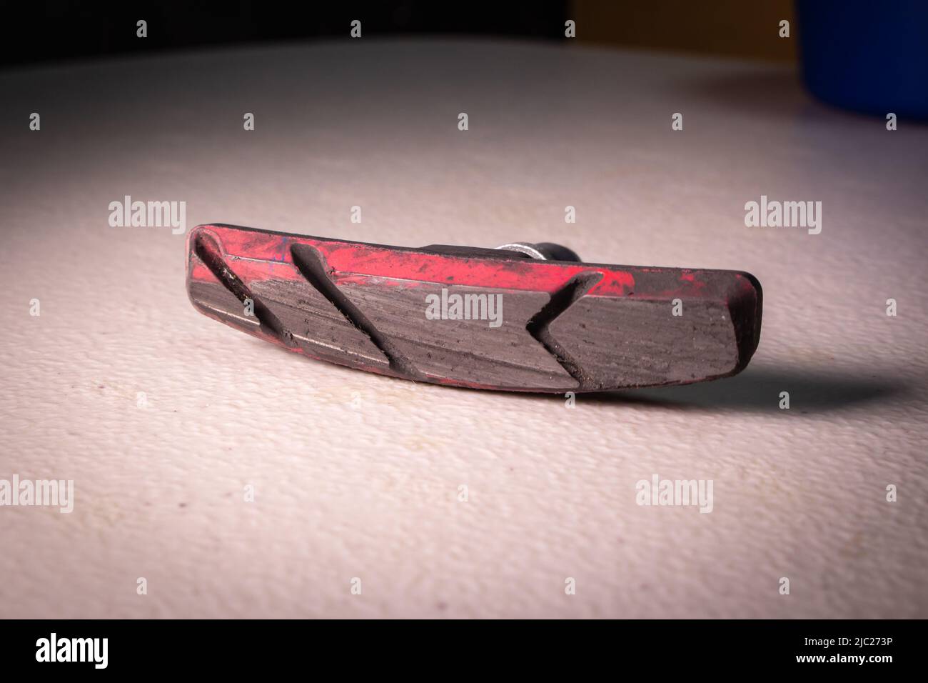 An old brake shoe for bicycle on a table in the dark mood. A brake in ...