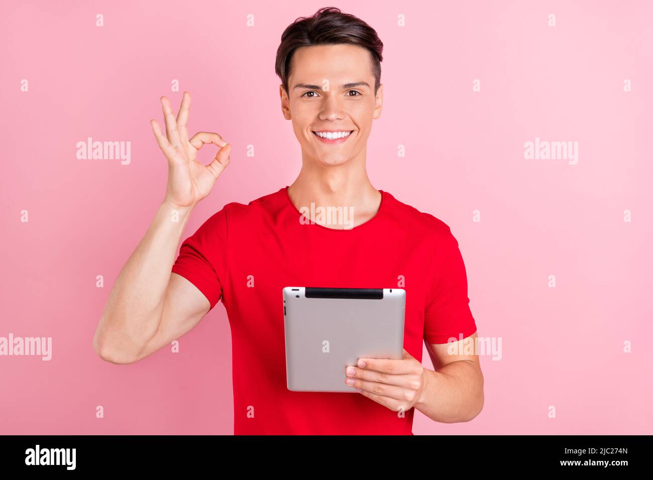 Photo of charming sweet young guy dressed red t-shirt showing okey ...