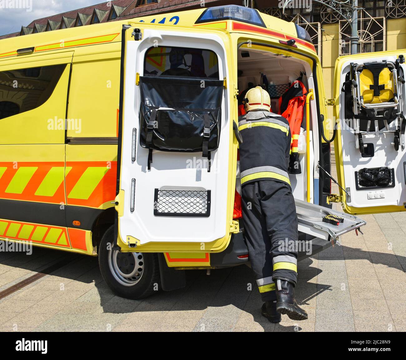Firefighter next to an ambulance Stock Photo - Alamy