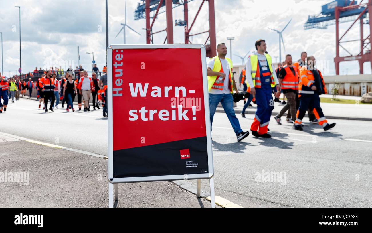 Hamburg, Germany. 09th June, 2022. Port workers walk past a sign ...