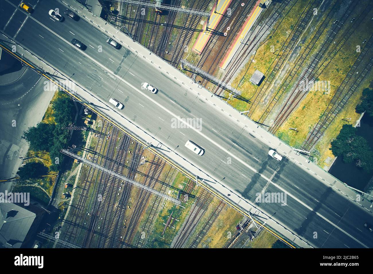 Cars drive by train overpass top down aerial view Stock Photo - Alamy