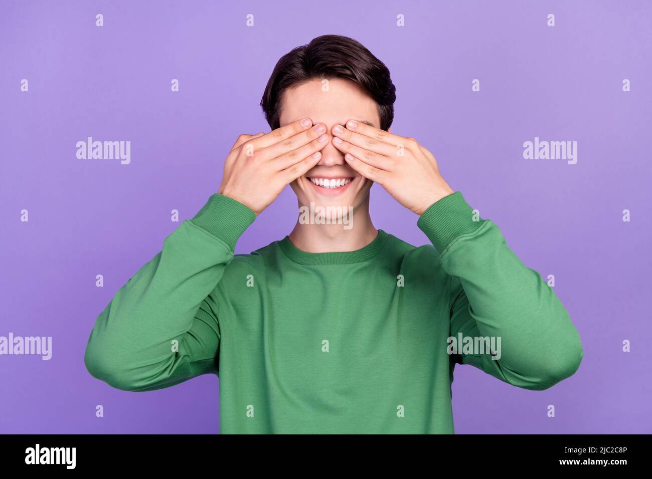 Photo of young guy happy positive smile close cover eyes hands hide ...
