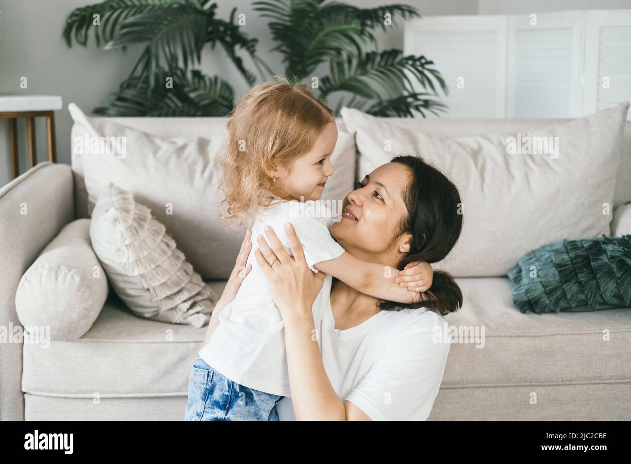 A mother gently hugs her four-year-old daughter Stock Photo - Alamy