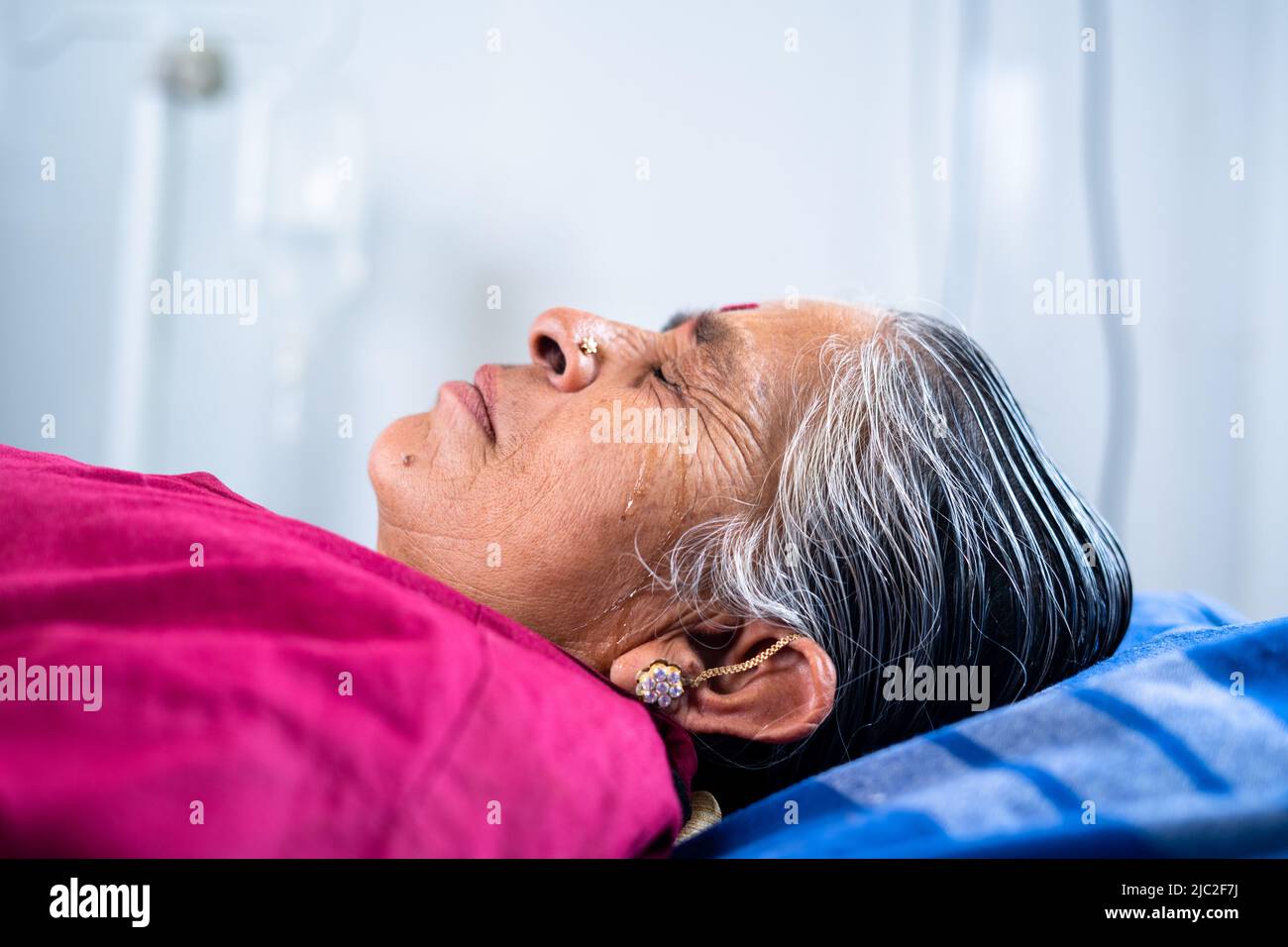Handheld close up headshot of crying sick elderly senior woman on ...