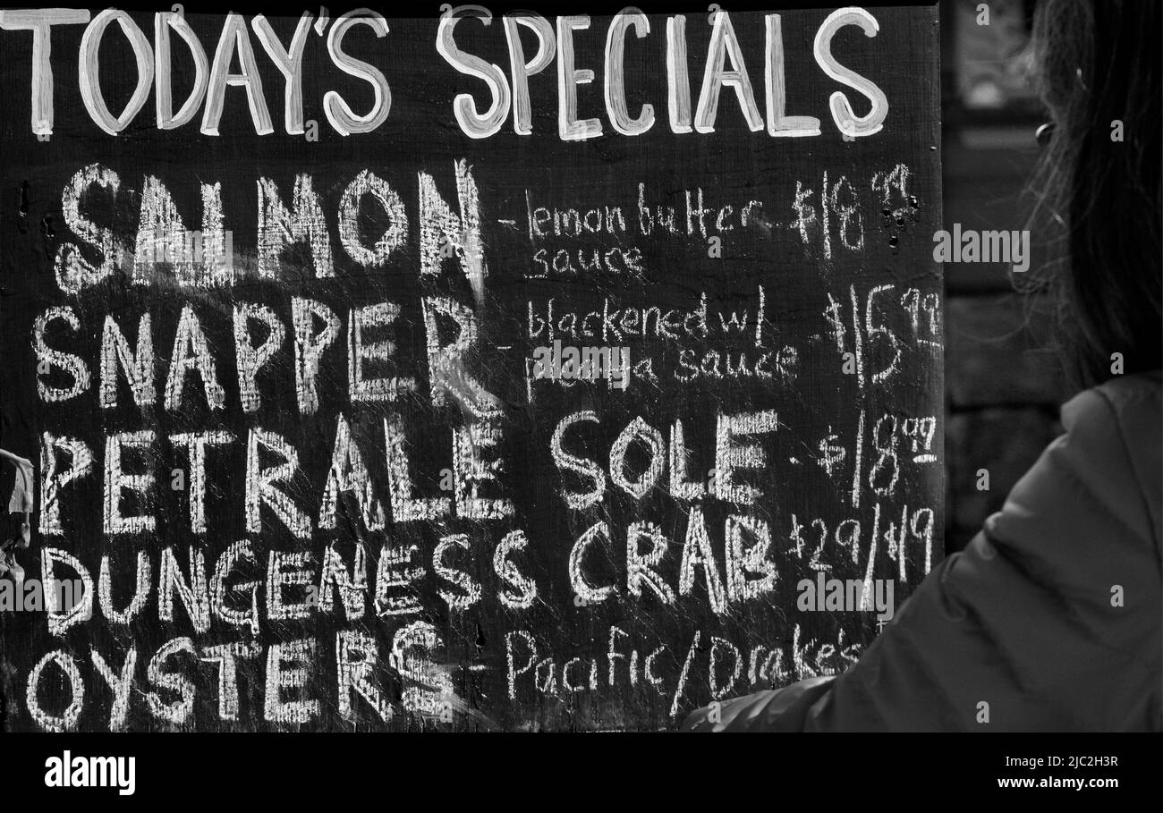 A seafood restaurant's menu specials are written on a chalkboard in the ...