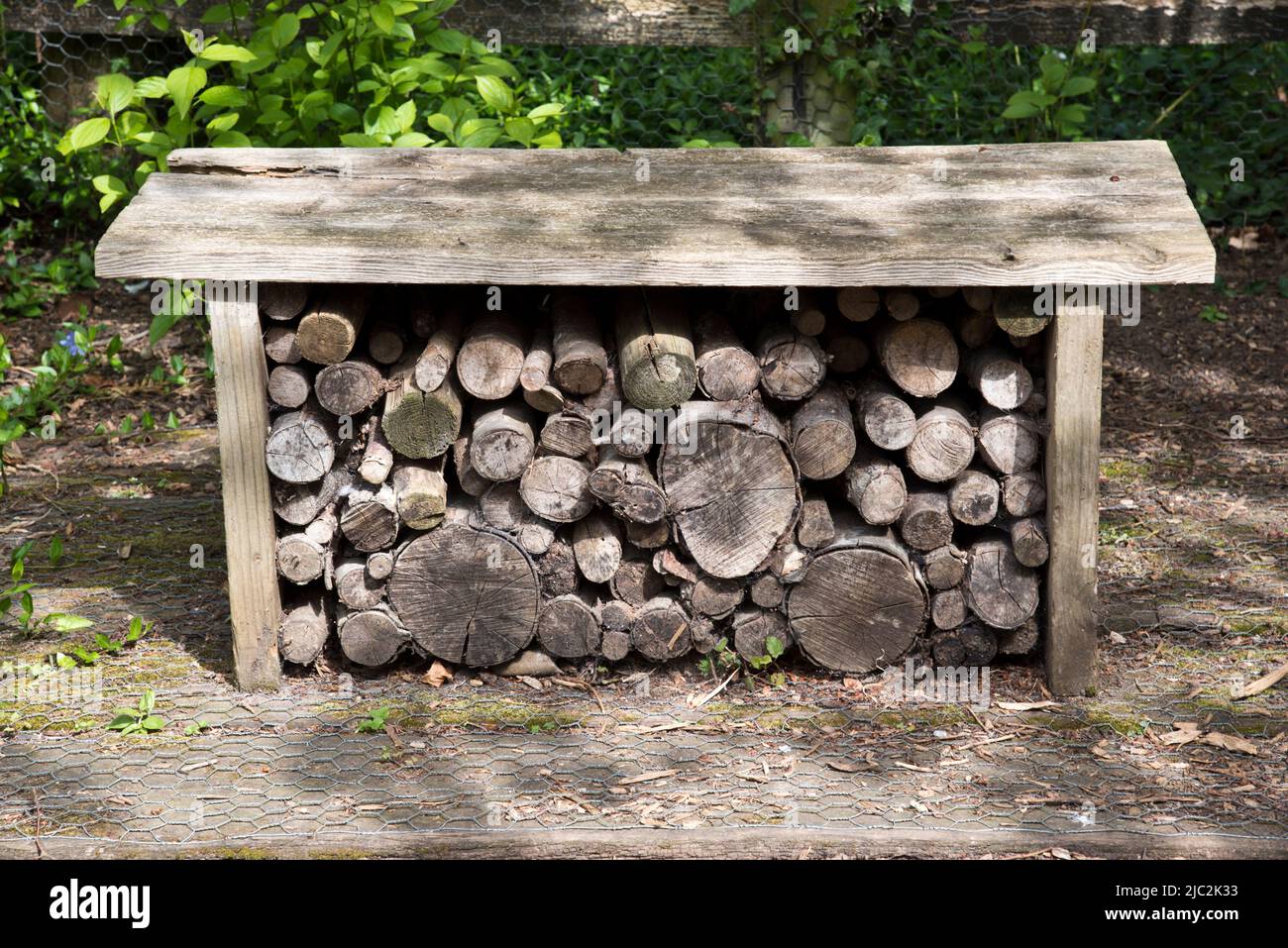 Ornate garden bench doubling as a log store Stock Photo - Alamy