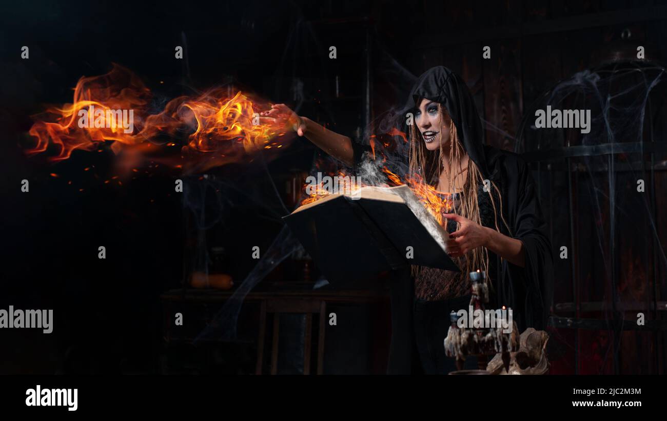 Halloween concept. Witch dressed black hood standing dark dungeon room ...