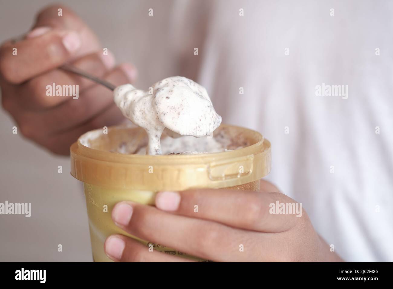 young men eating vanila flavor ice cream in a container Stock Photo - Alamy