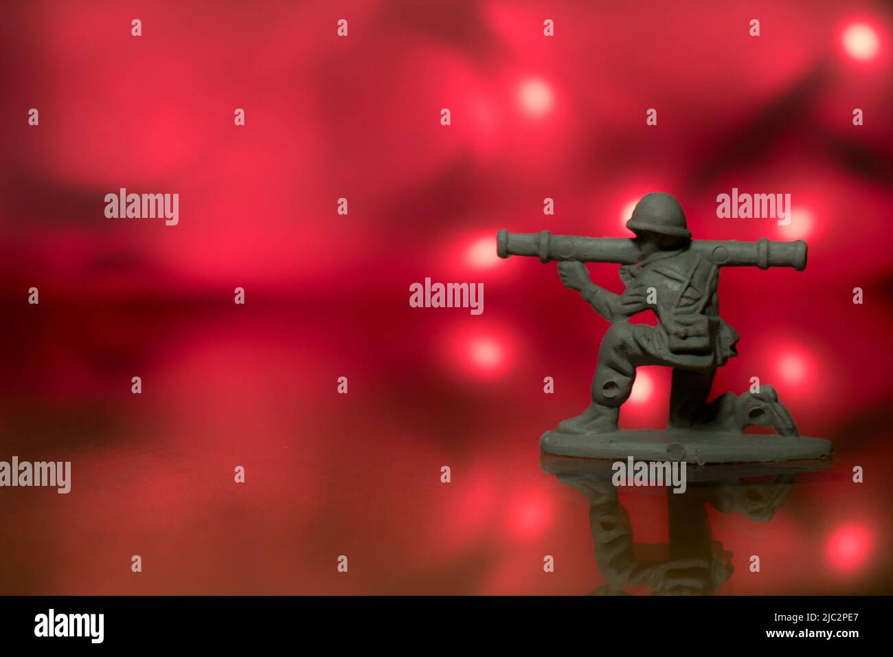 Miniature toy soldier with weapon in hand, reddish background Stock ...