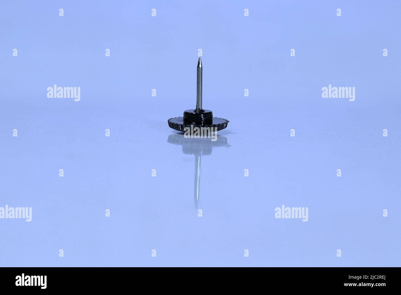Black push pin on white surface, pointy side up Stock Photo - Alamy