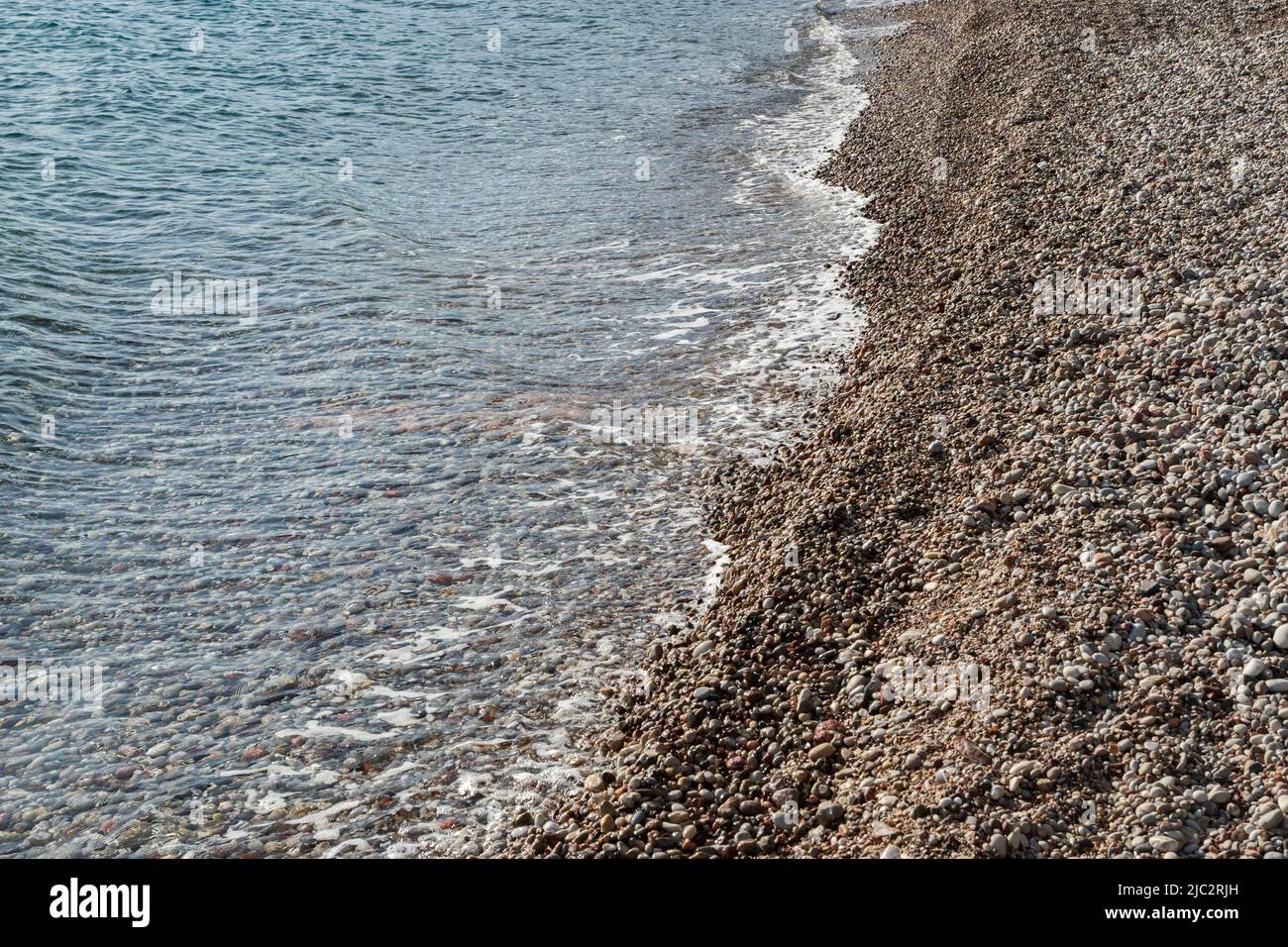 Line between rocky beach and sea water closeup Stock Photo - Alamy
