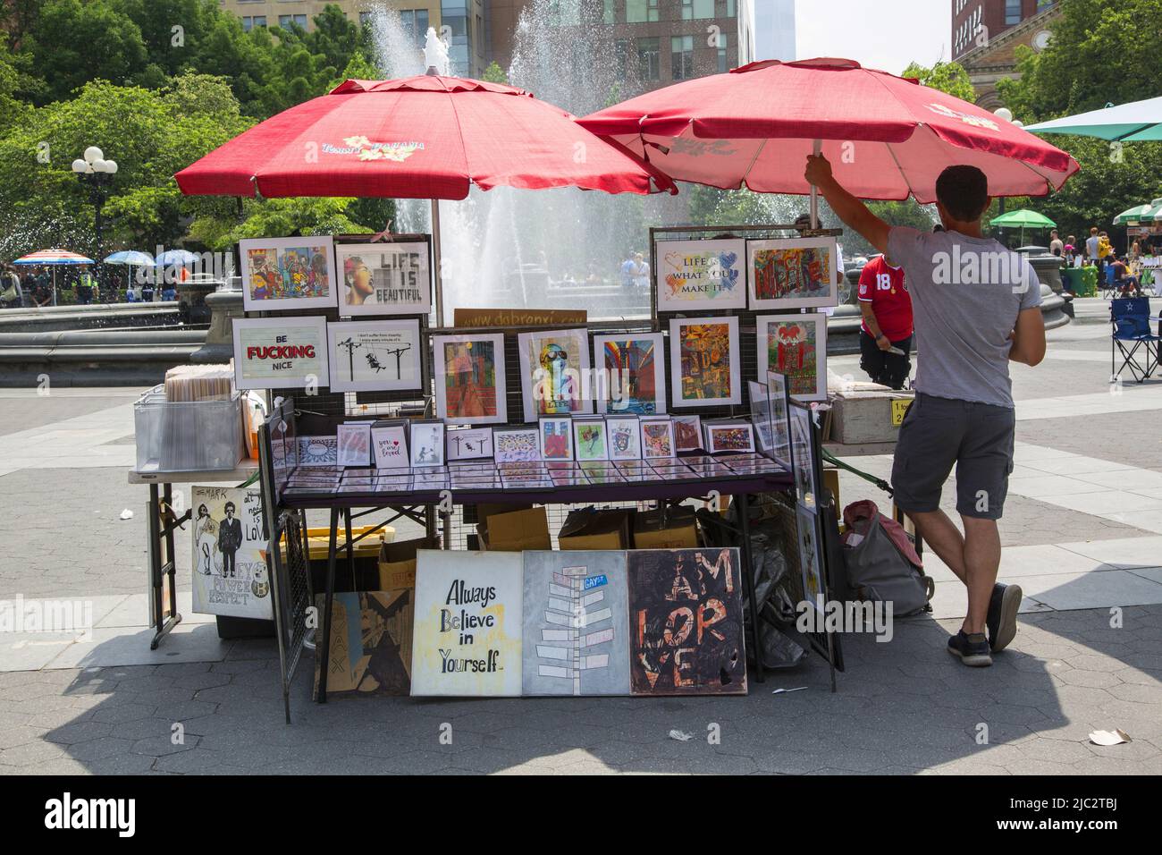 Vendor sells a variety of art, cards and posters with various sayings ...