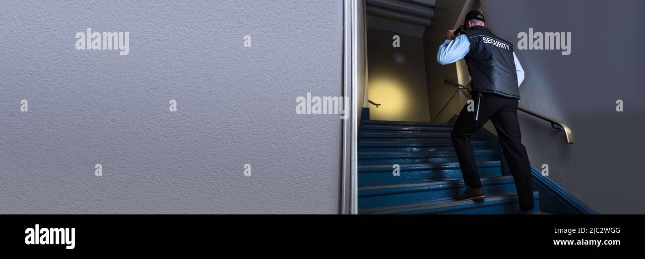 Rear View Of A Male Security Officer With Flashlight Stock Photo - Alamy