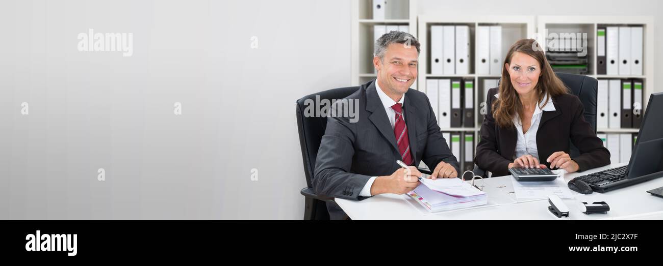 Portrait Of Smiling Accountant Calculating Taxes In Office Stock Photo ...