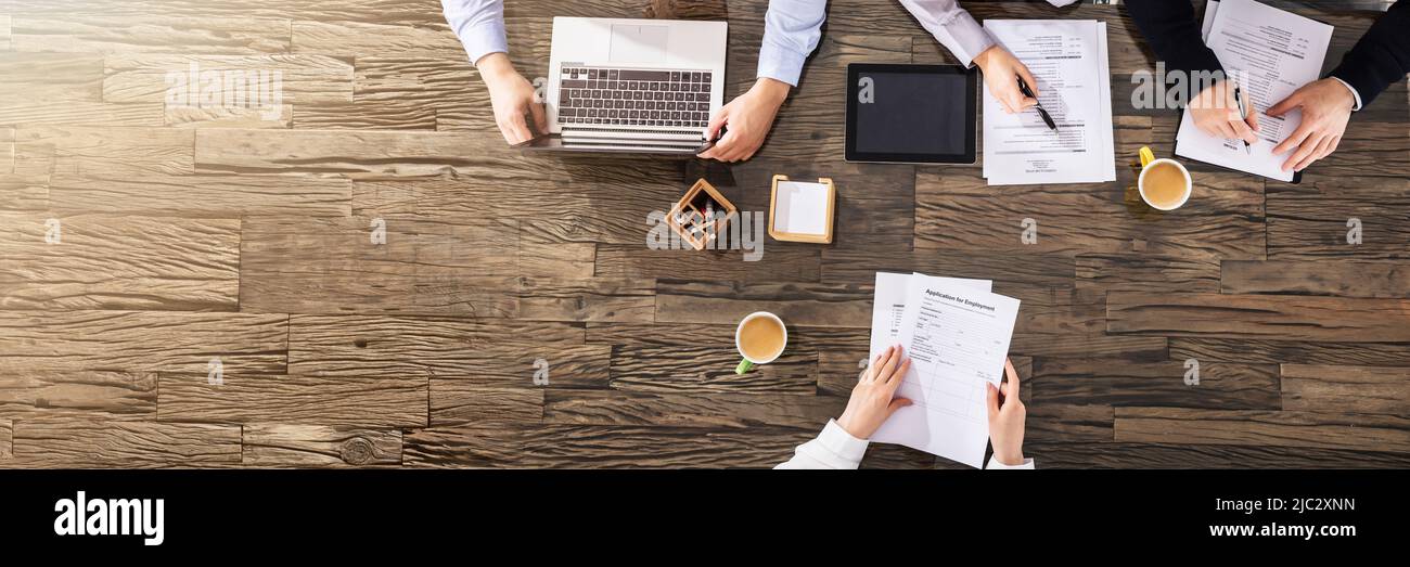 Elevated View Of Businesspeople Taking An Interview Over The Wooden ...