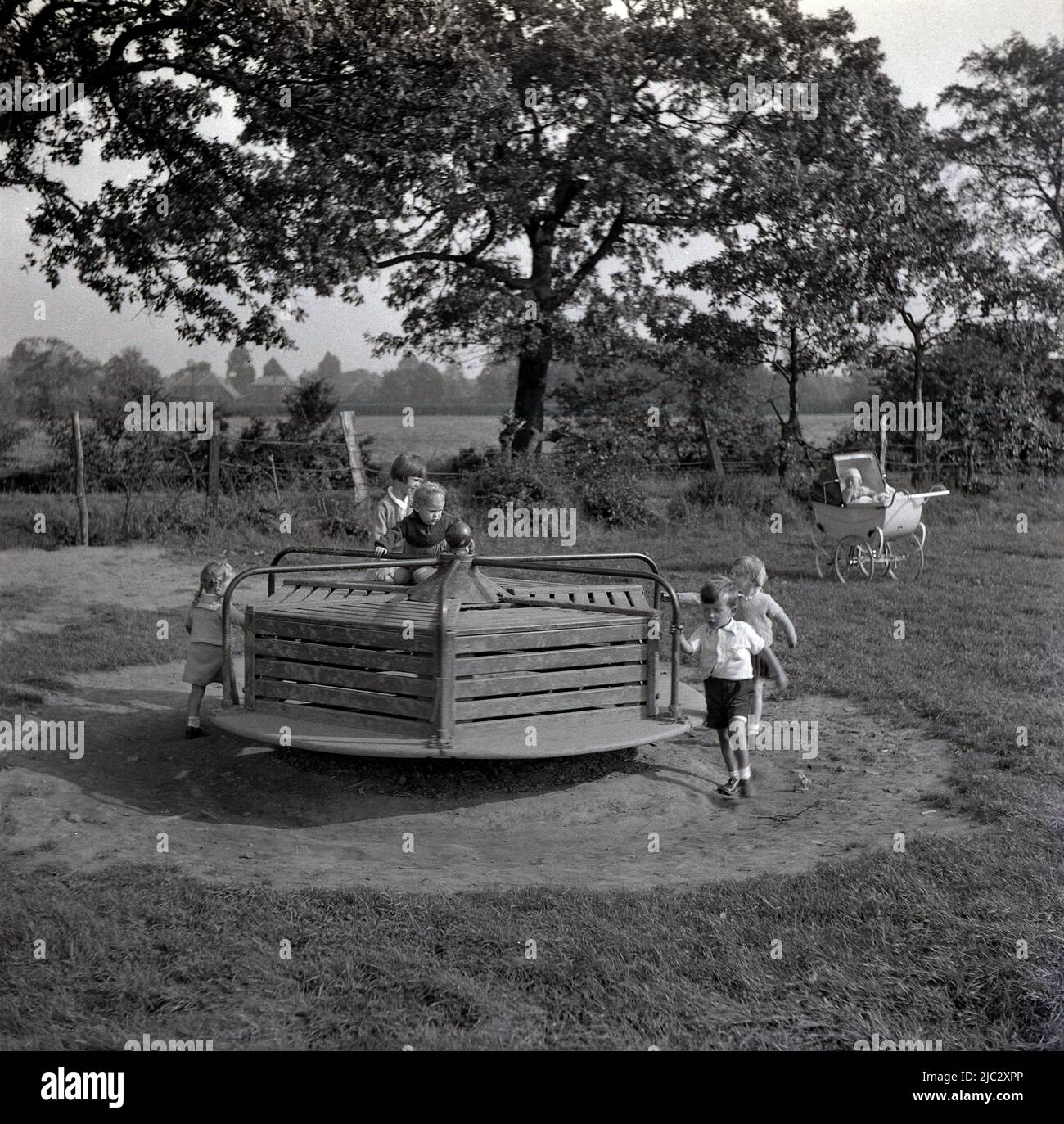 1950s, historical, outside in a countryside playground, young children ...