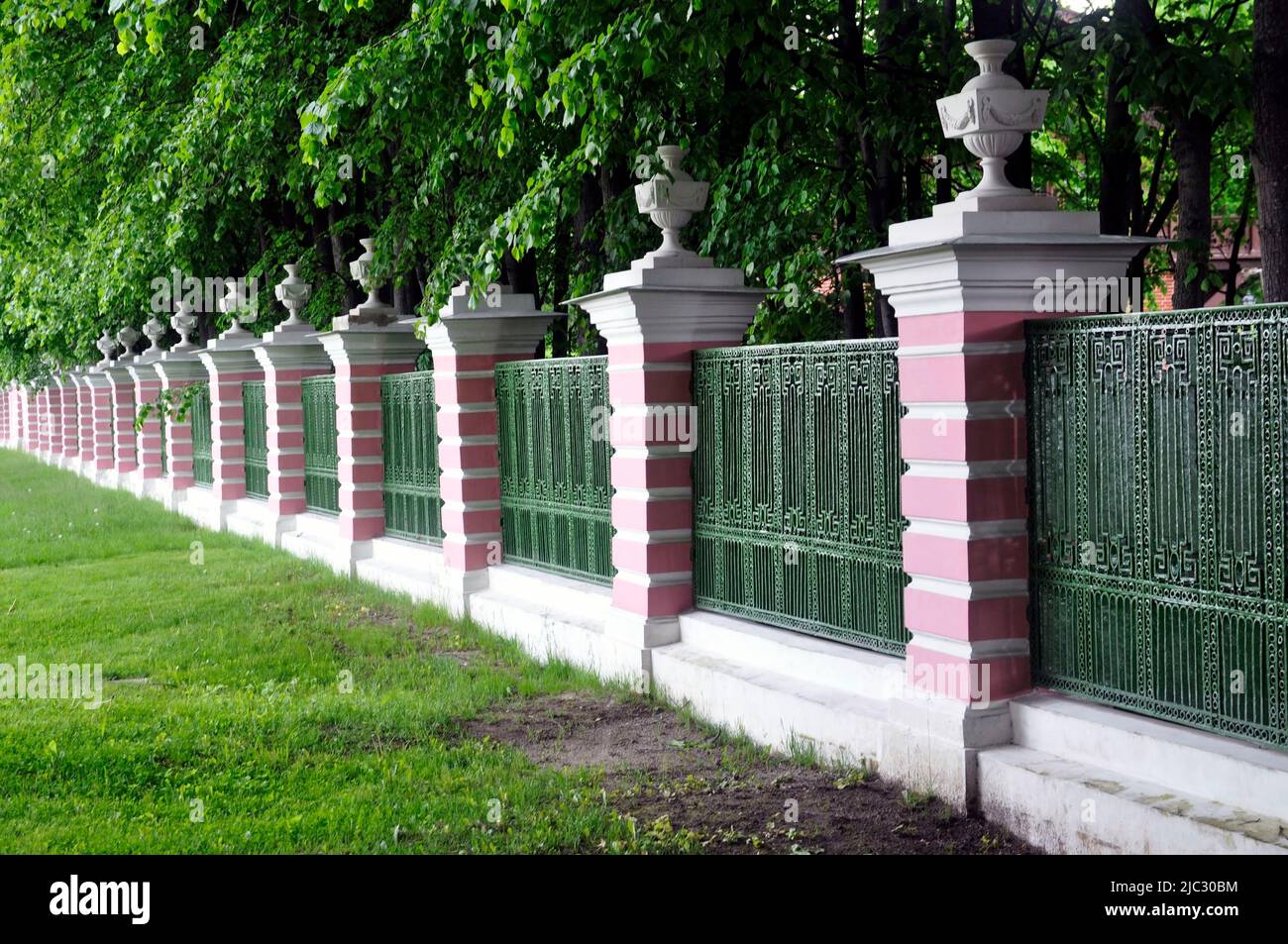 Old brick plastered fence with a metal grate. Urban landscape Stock ...