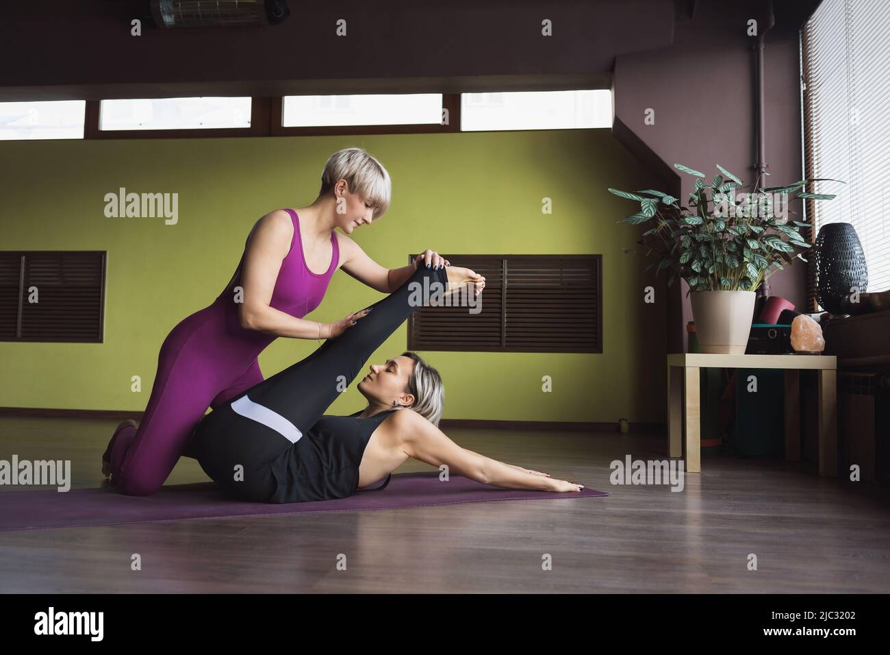 The trainer helps the student to perform an exercise to stretch the ...