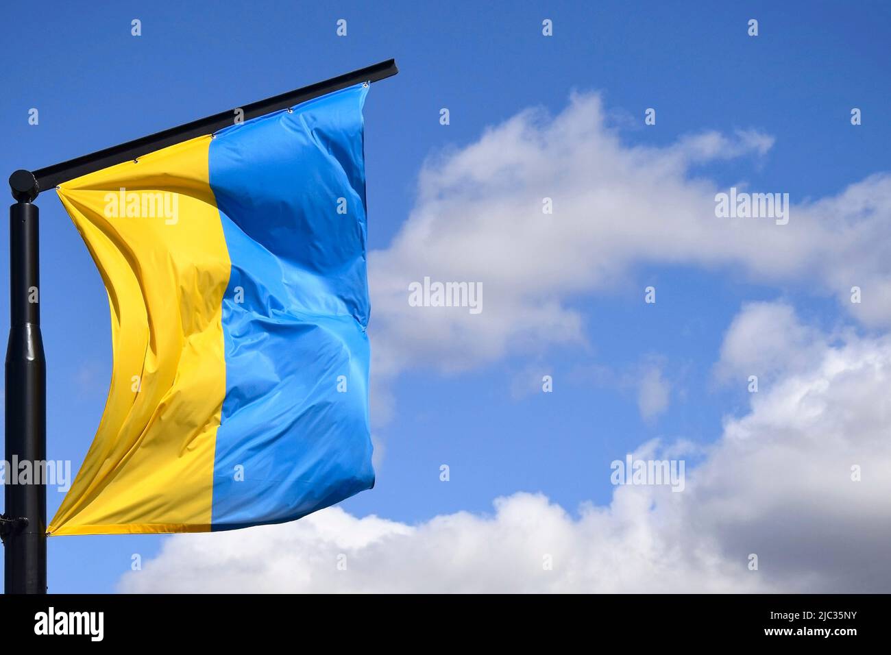 Ukrainian flag on flagpole against the blue cloudless sky. The official ...
