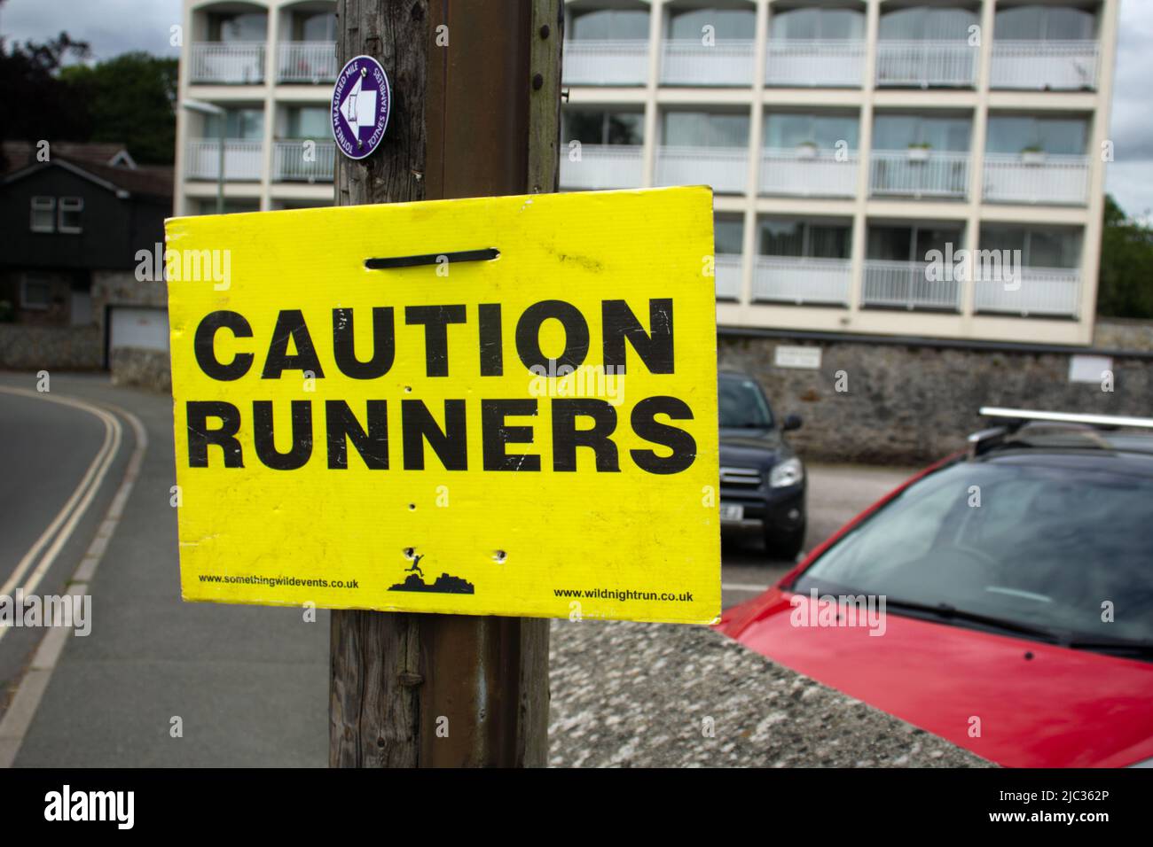 TOTNES, UK - JUNE 26, 2021 Caution Runners sign in black letters on a ...