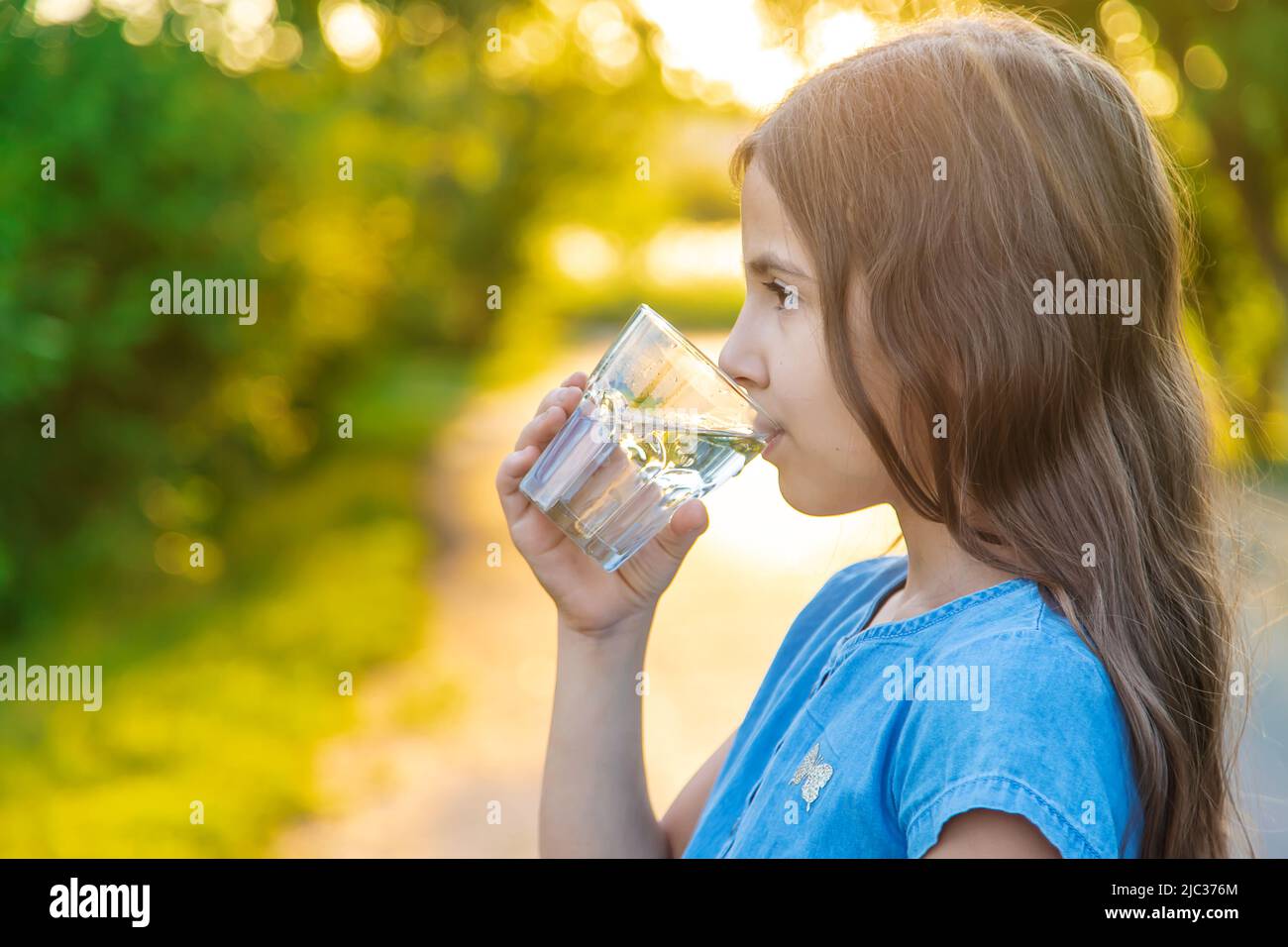 The child drinks water from a glass. Selective focus Stock Photo - Alamy