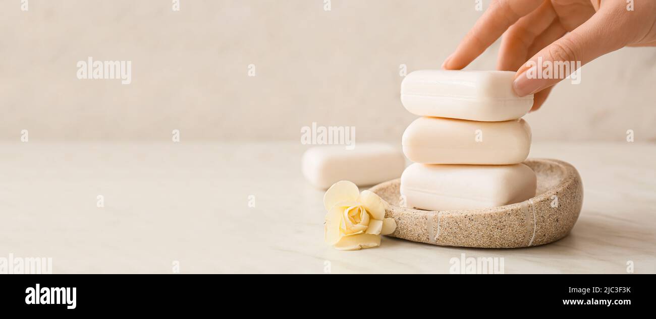 Female hand with soap bars on light background with space for text ...