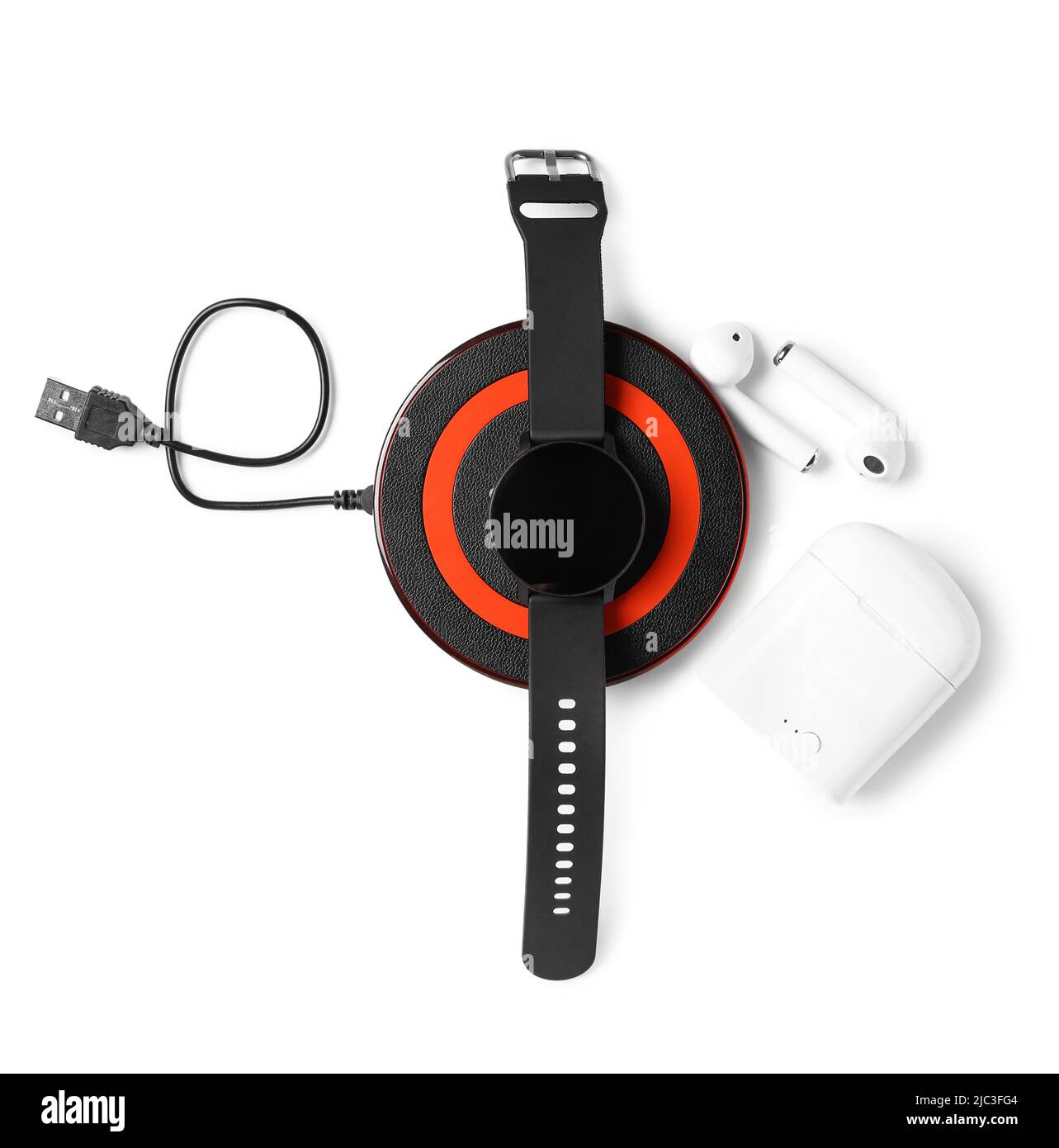 Wireless charger pad, smartwatch and earphones on white background ...