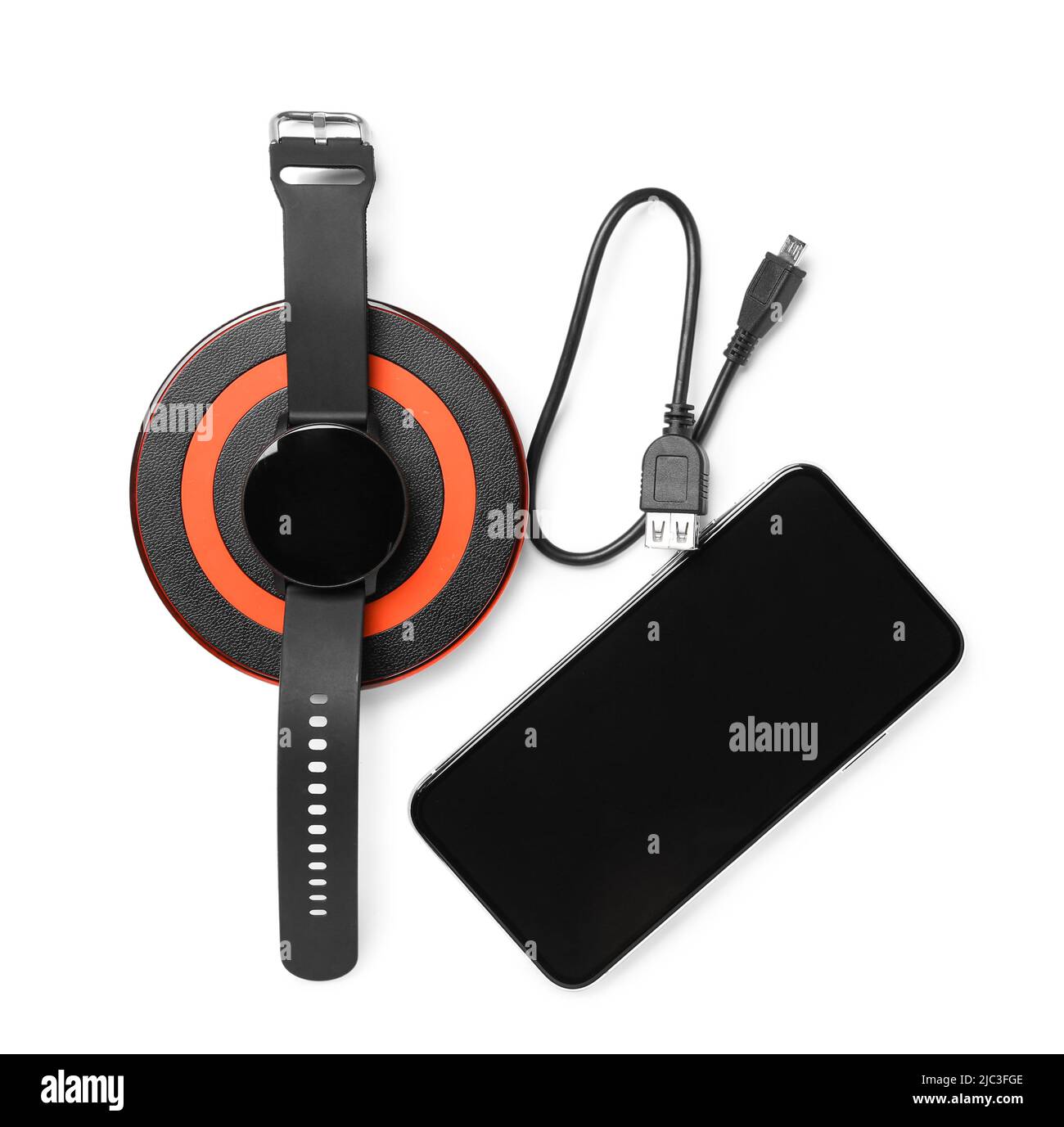 Wireless charger pad, smartwatch and mobile phone on white background ...