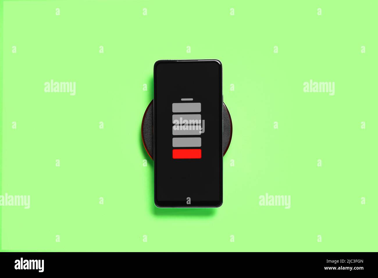 Mobile phone charging with wireless pad on green background Stock Photo ...