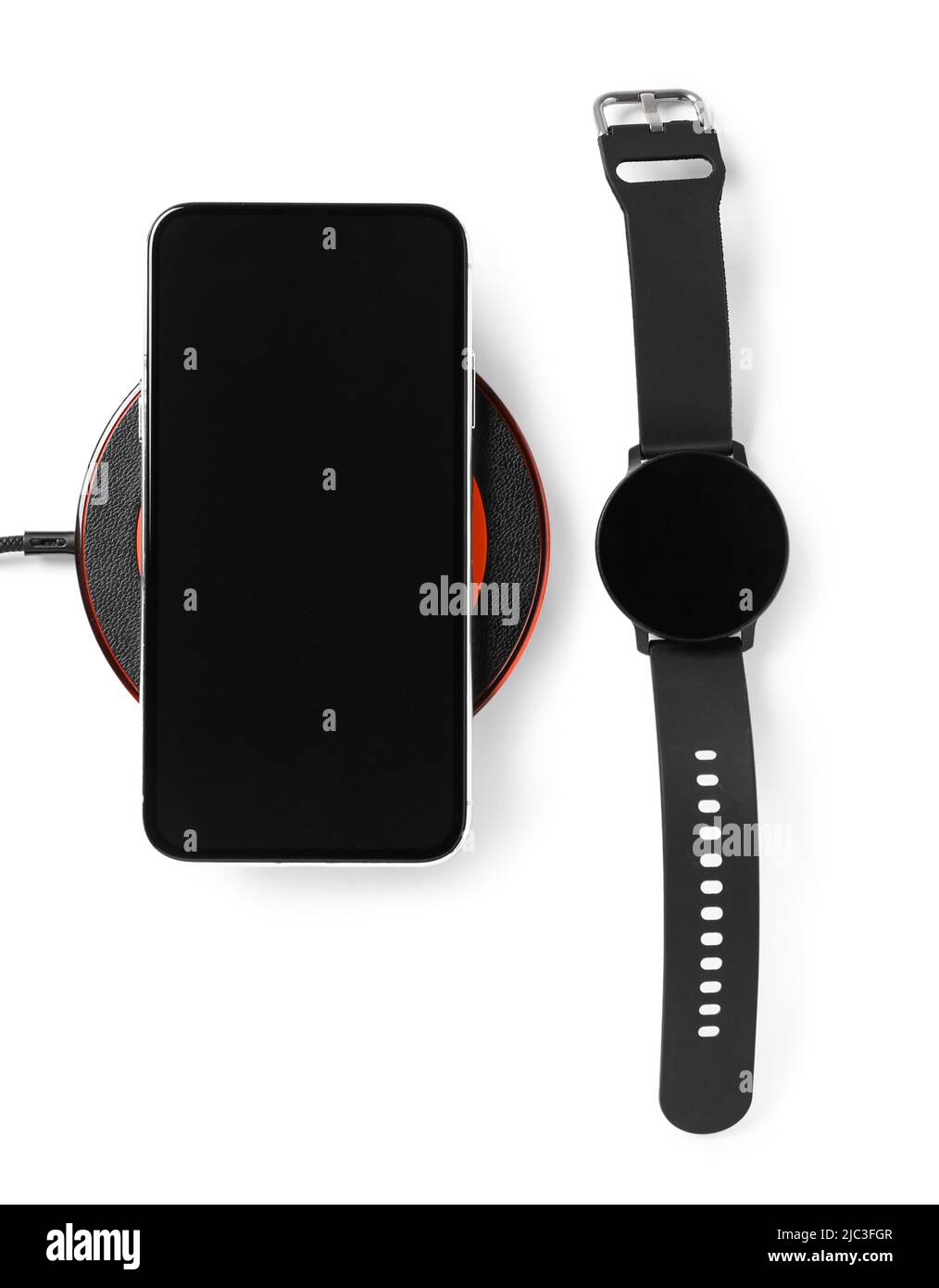 Wireless charger pad, modern smartwatch and mobile phone on white ...