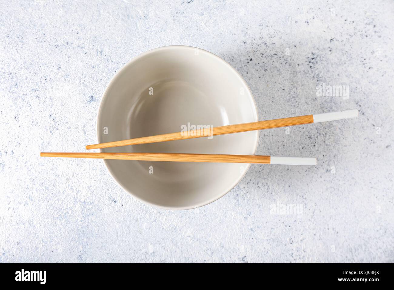 Chinese bowl with chopsticks on light background Stock Photo - Alamy
