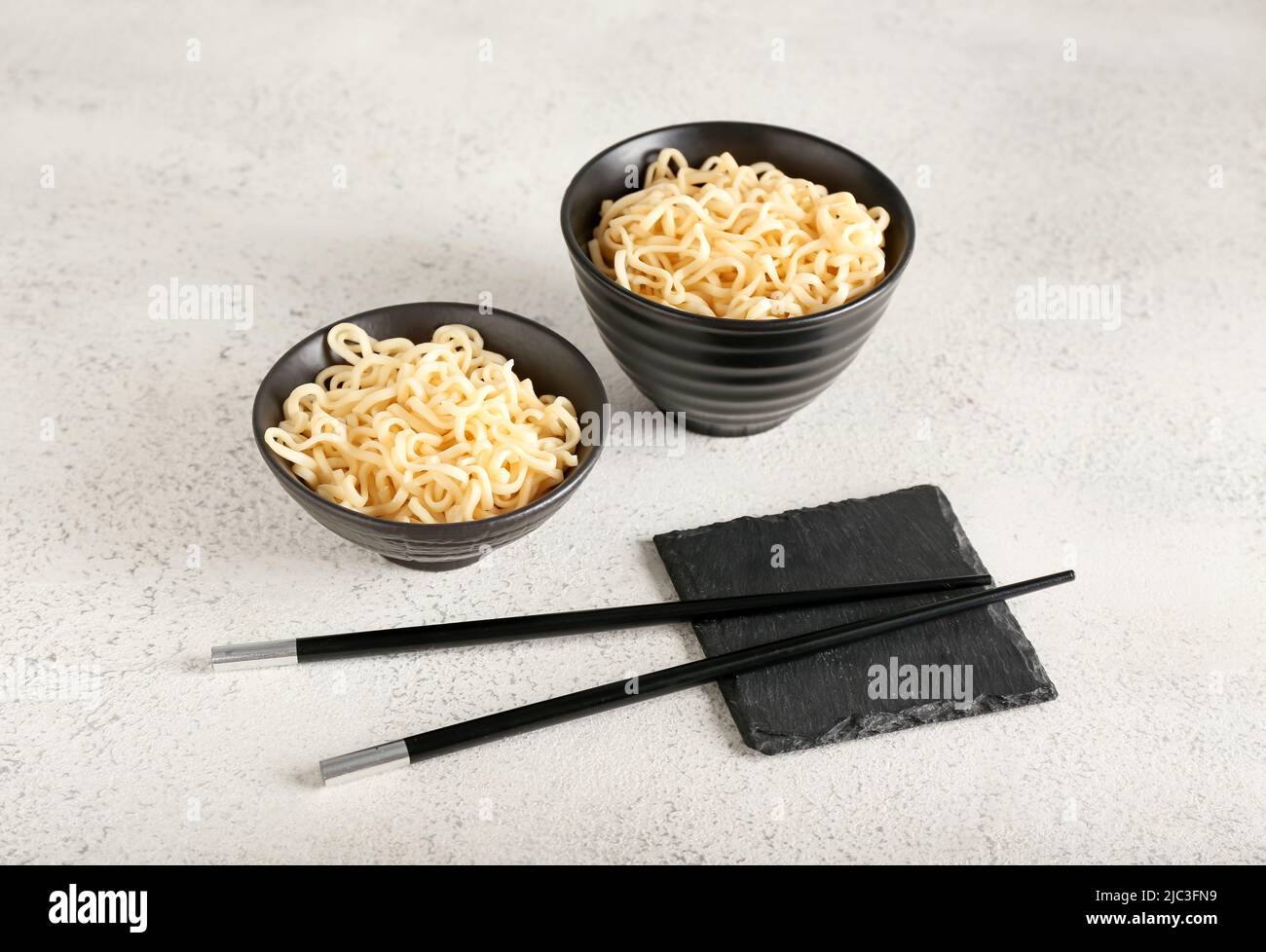 Bowls with tasty noodles on light background Stock Photo - Alamy