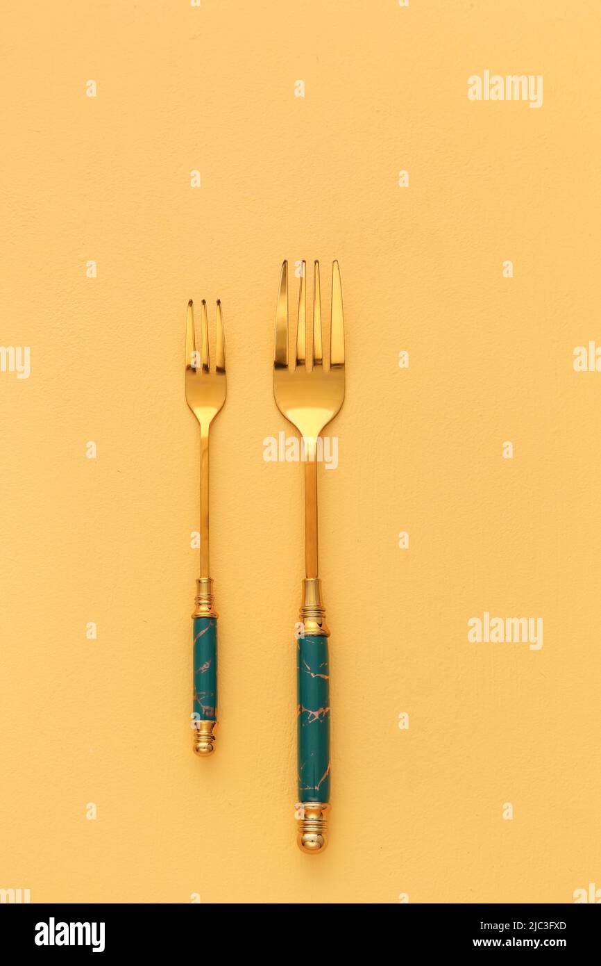 Stylish stainless steel forks on yellow background Stock Photo - Alamy