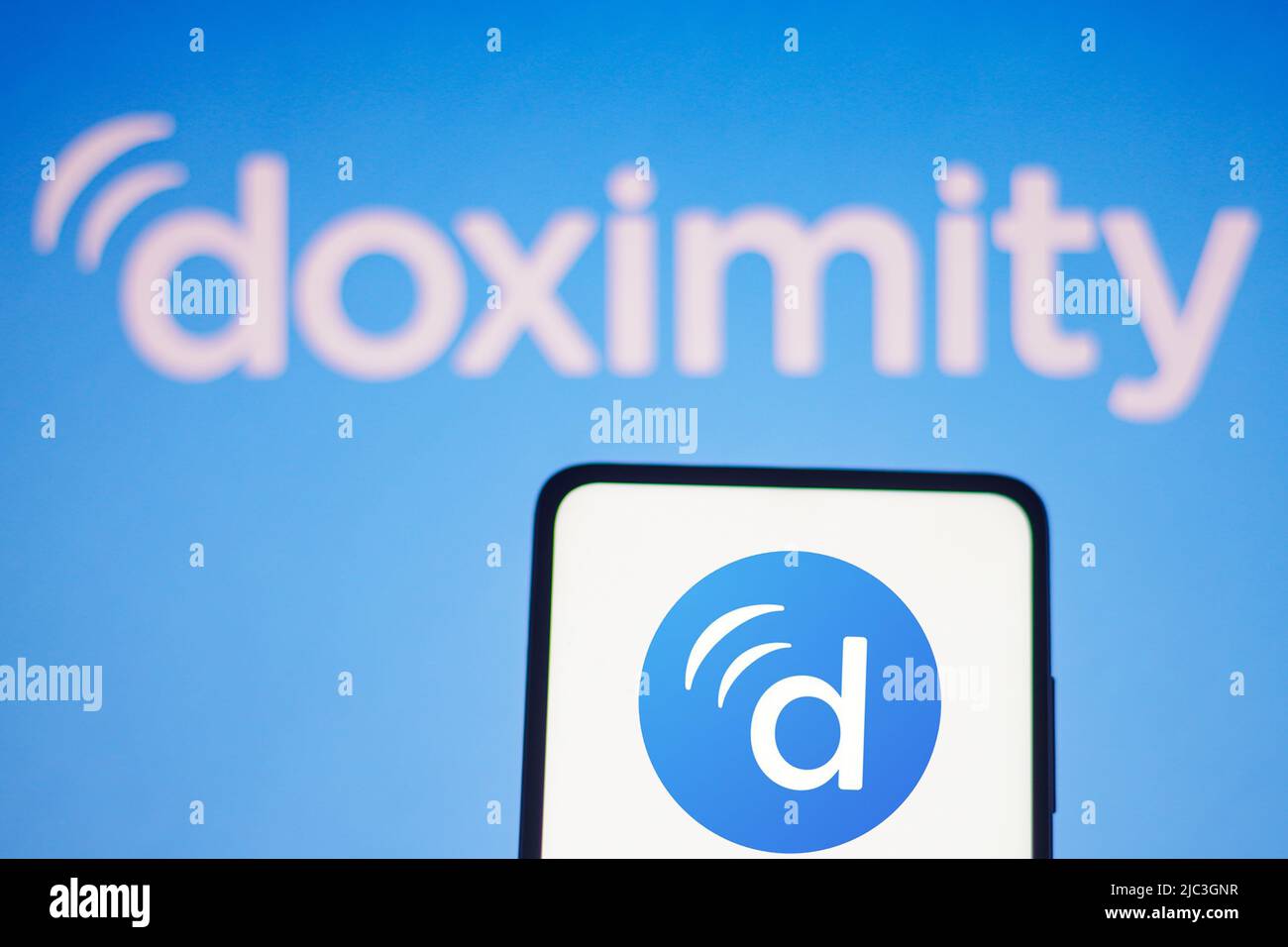 In this photo illustration, the Doximity logo is displayed on a smartphone screen and in the ...