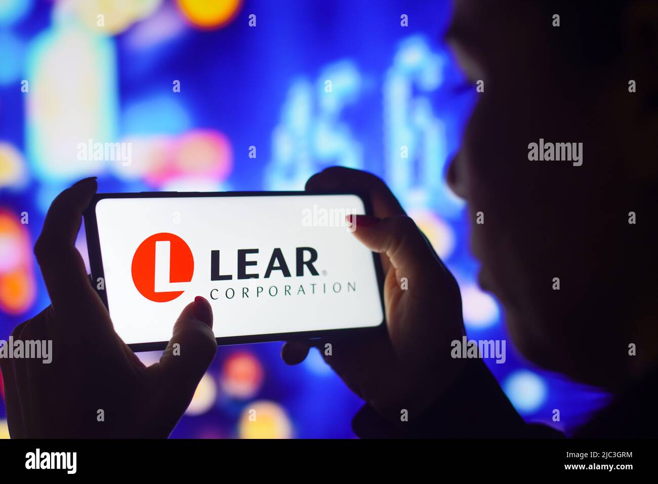 In this photo illustration, a silhouetted woman holds a smartphone with ...