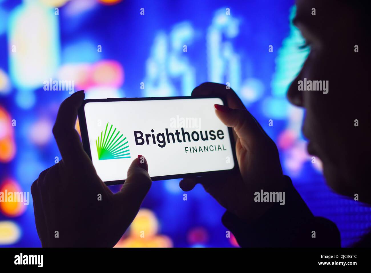 In this photo illustration, a silhouetted woman holds a smartphone with ...