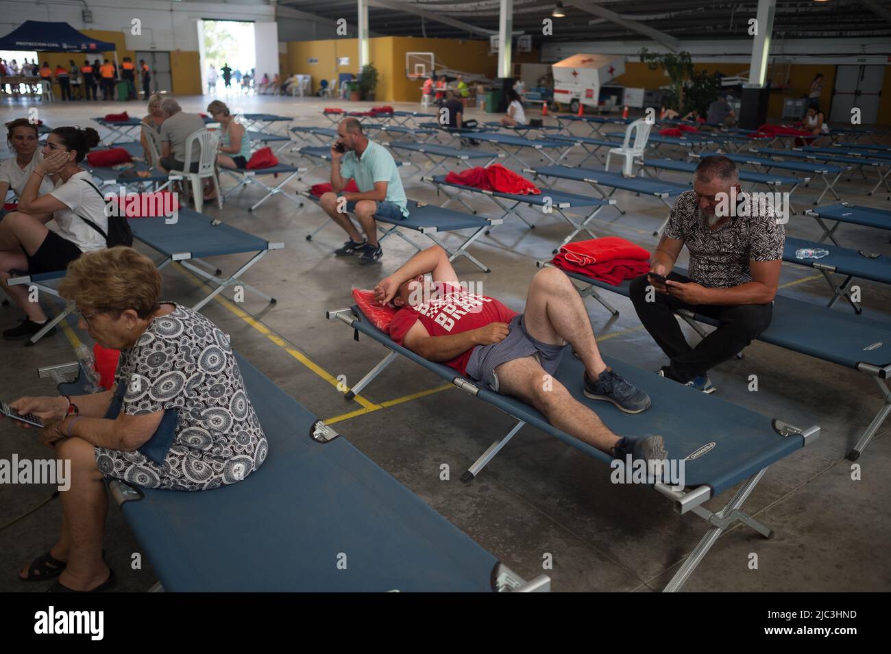 People evacuated from their houses are seen resting inside an emergency ...