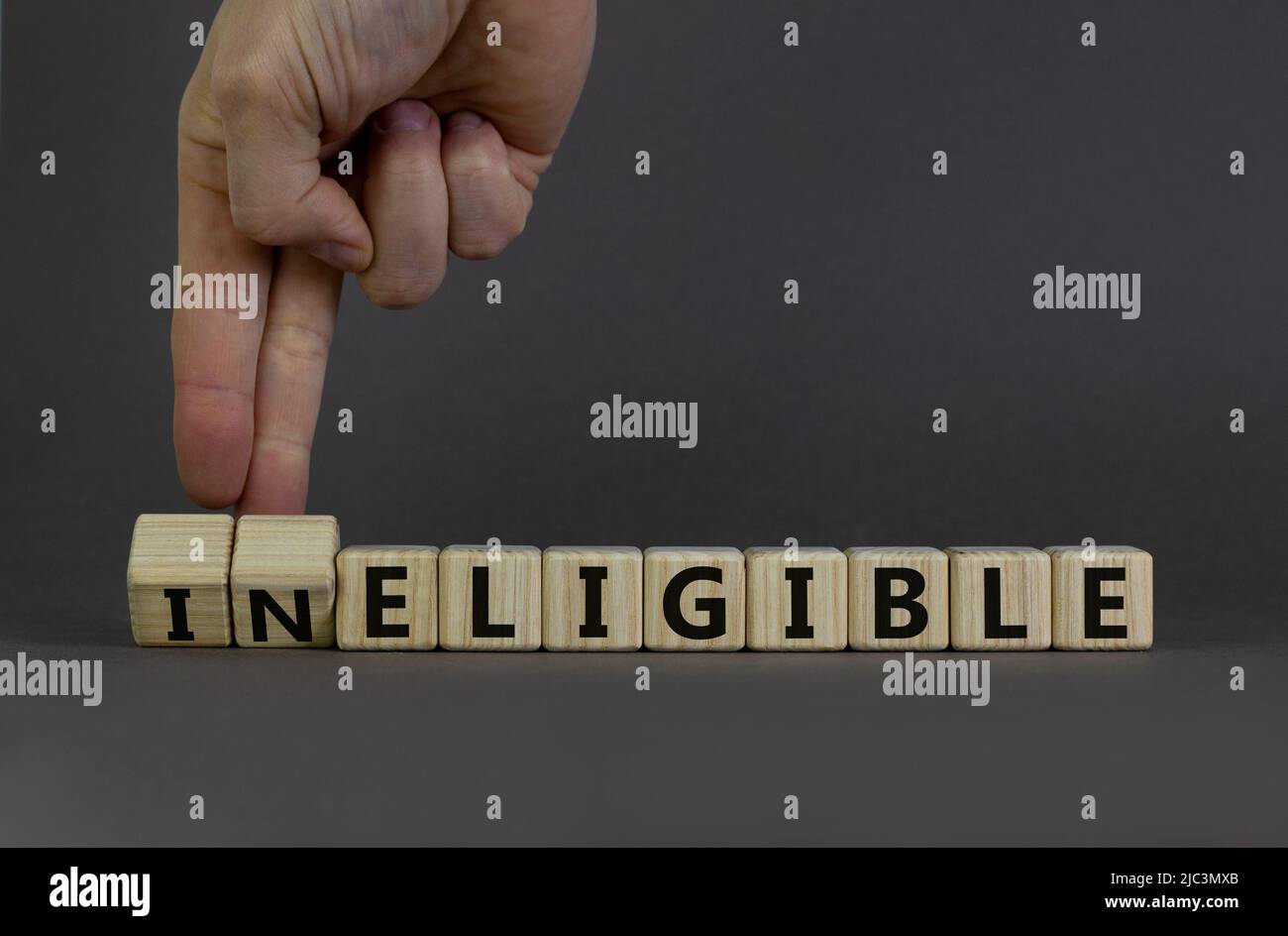 Eligible or ineligible symbol. Businessman turns wooden cubes and ...