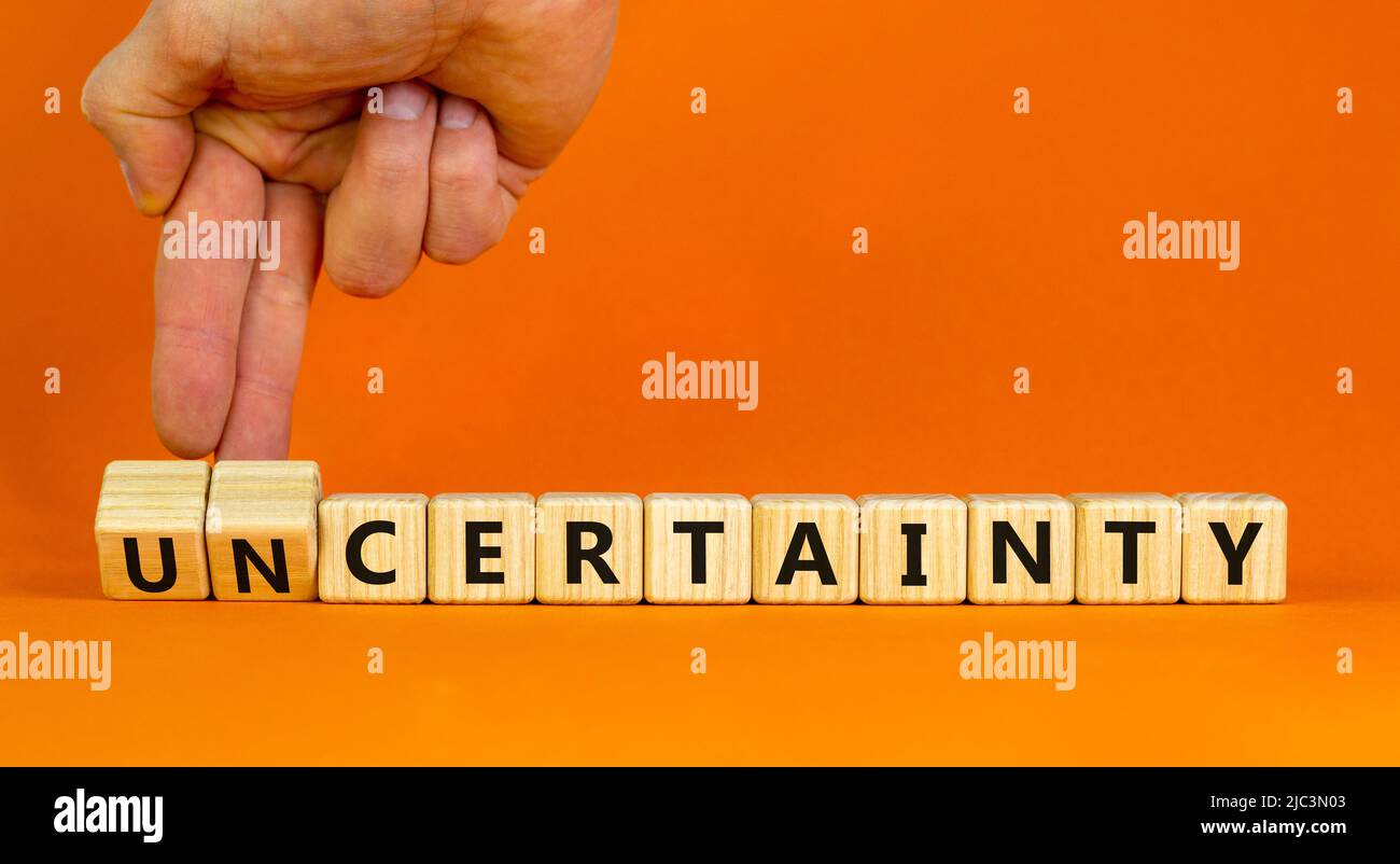 Certainty or Uncertainty symbol. Businessman turns wooden cubes and ...