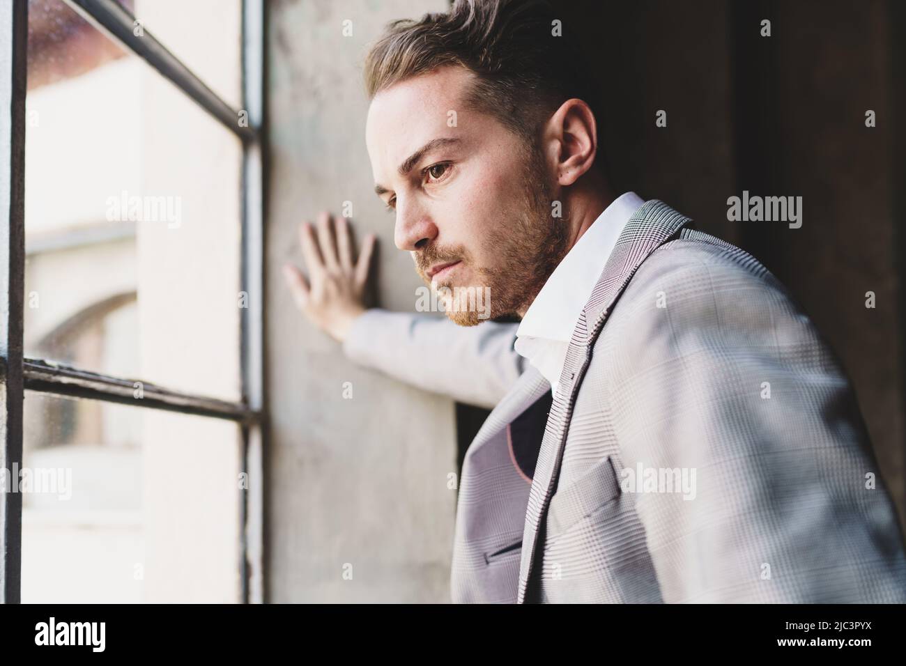 worried young businessman from the future looks out of the window with ...