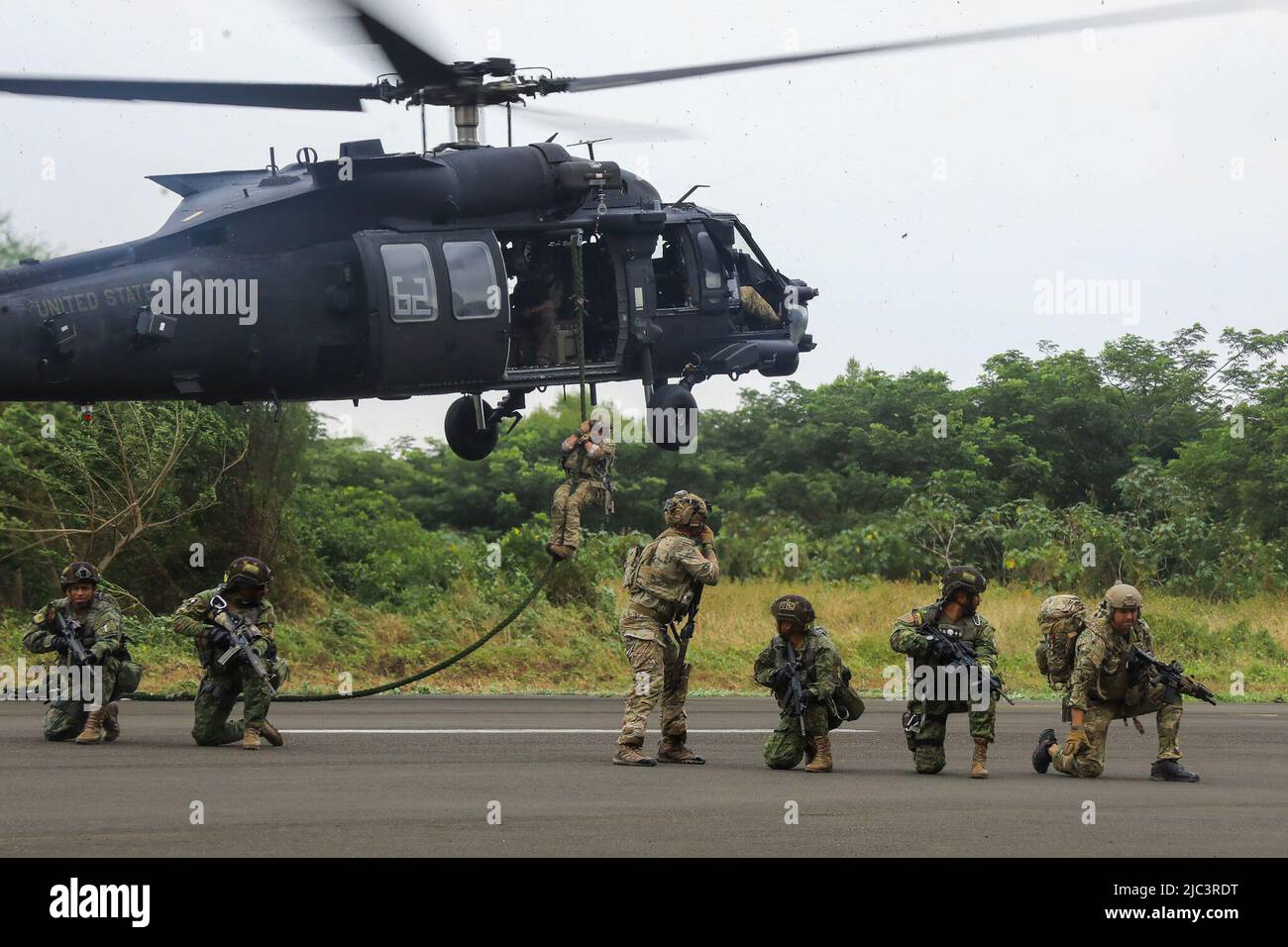Members of the 7th Special Forces Group (Airborne) slide down a rope ...