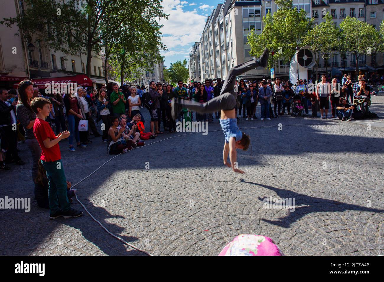 05-07-2016 Paris. Street performance of circus acrobats and a crowd of ...
