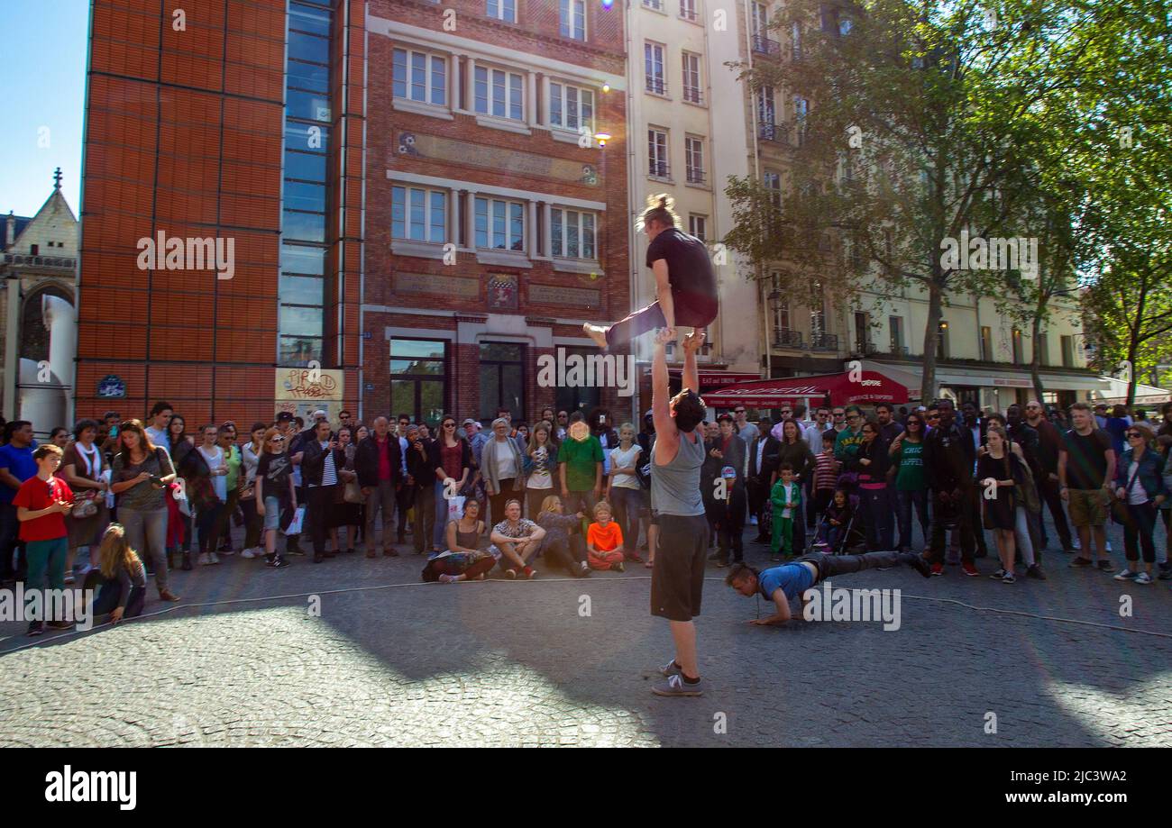 05-07-2016 Paris. Street performance of circus acrobats and a crowd of ...