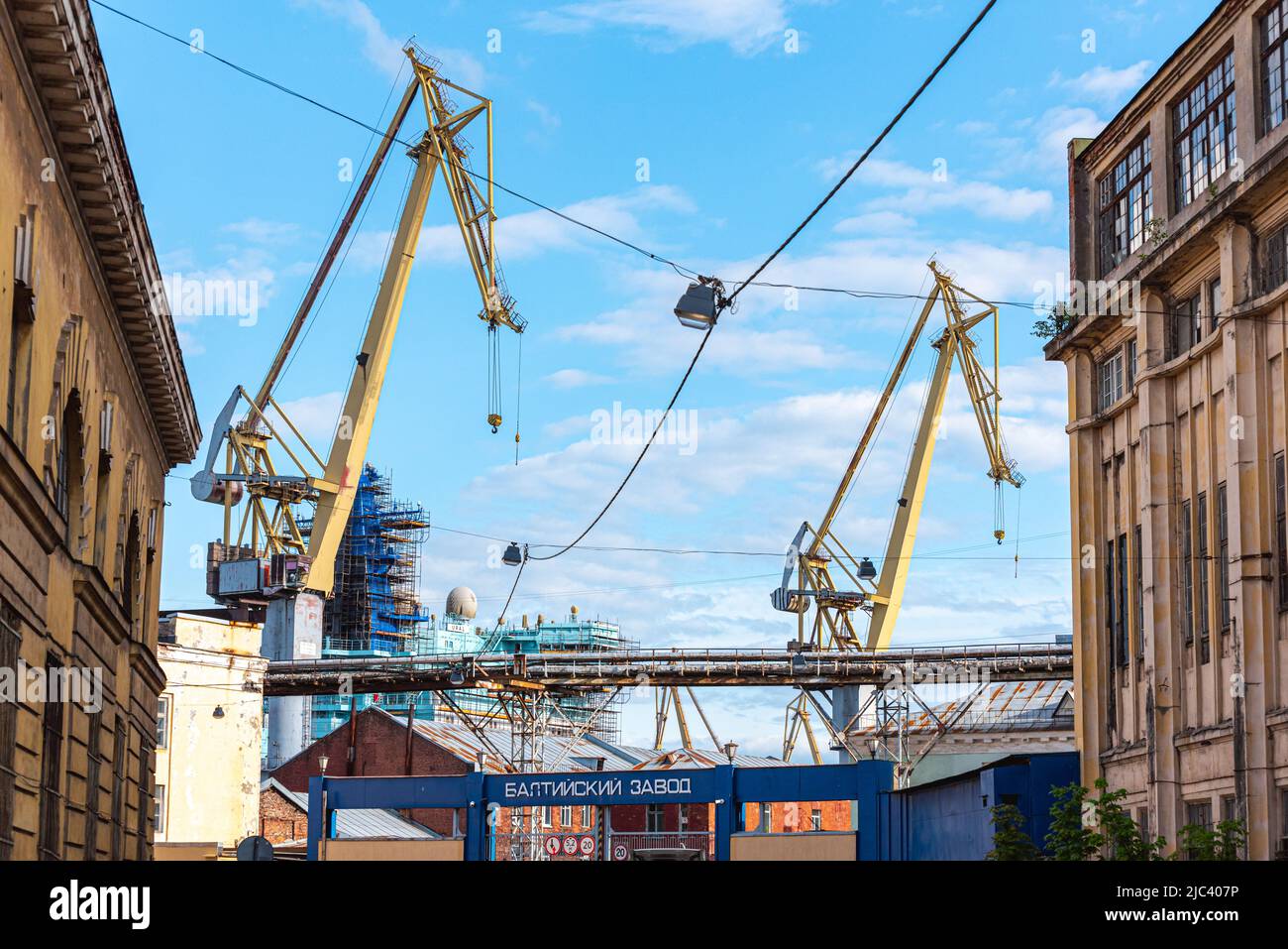 Cranes in Baltic Shipyard (which is written on the gate in Russian) in ...