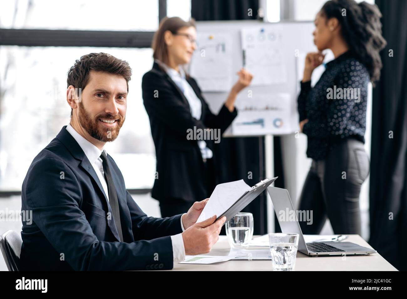 Positive successful handsome business man in a formal suit, sit at ...