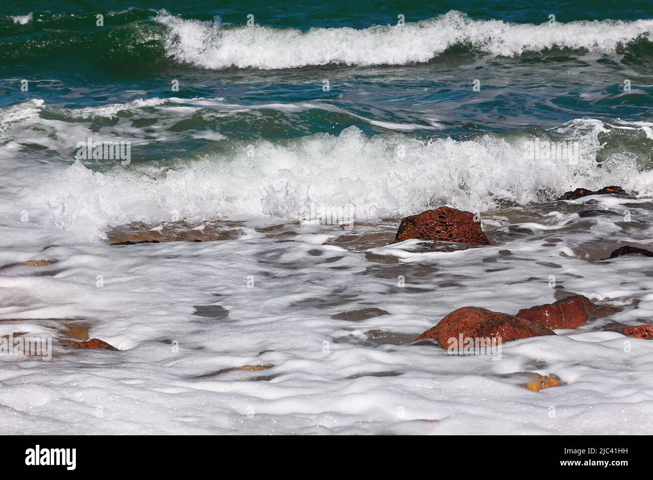 Sea waves with foam beating the rocks Stock Photo - Alamy