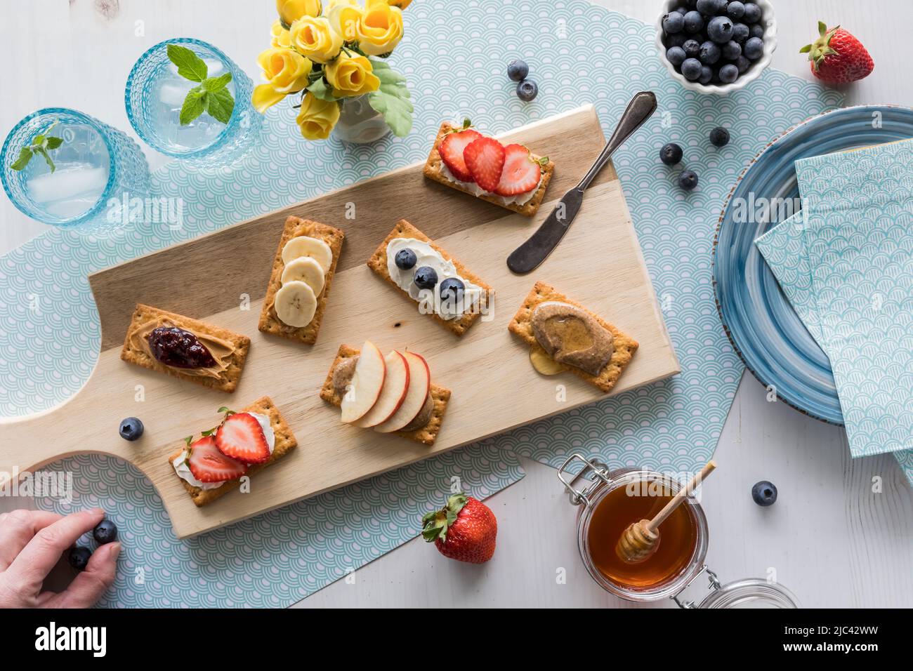 Breakfast crackers with various toppings of fresh fruit and cream ...