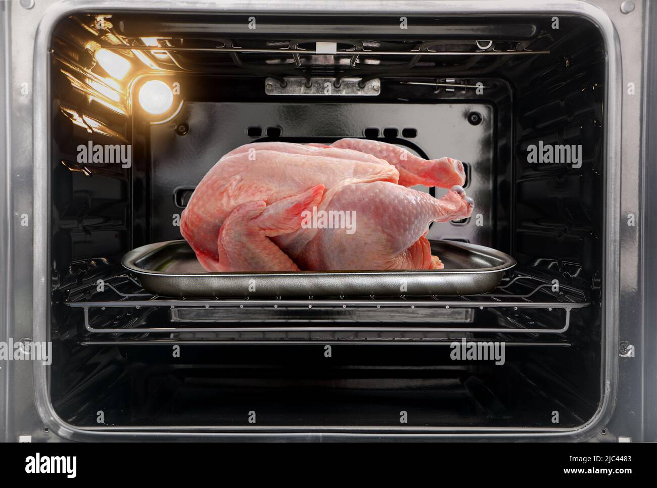 Whole raw turkey in the oven Stock Photo - Alamy