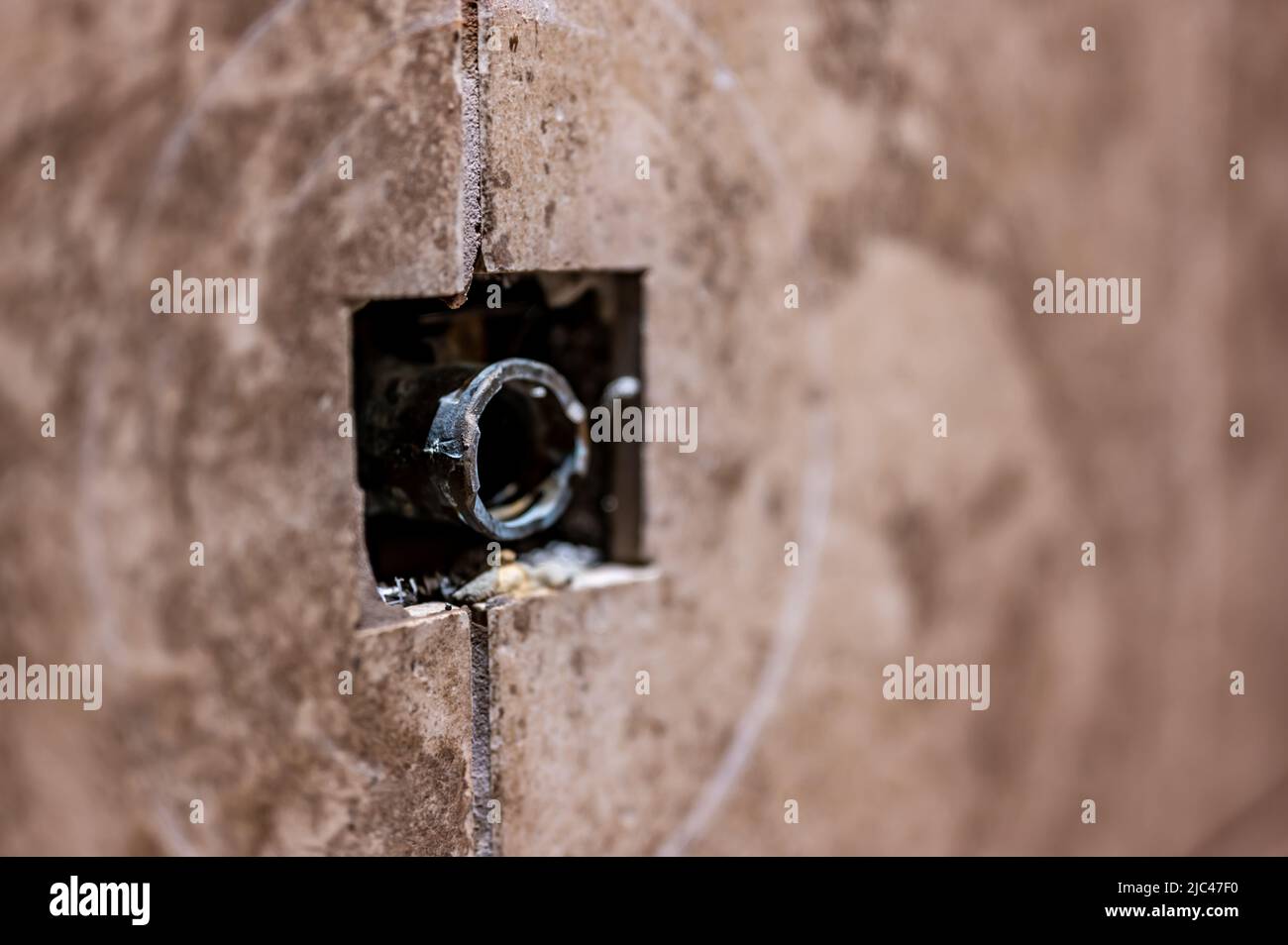 Cut-out section in bathroom shower tile with pipe connection protruding ...